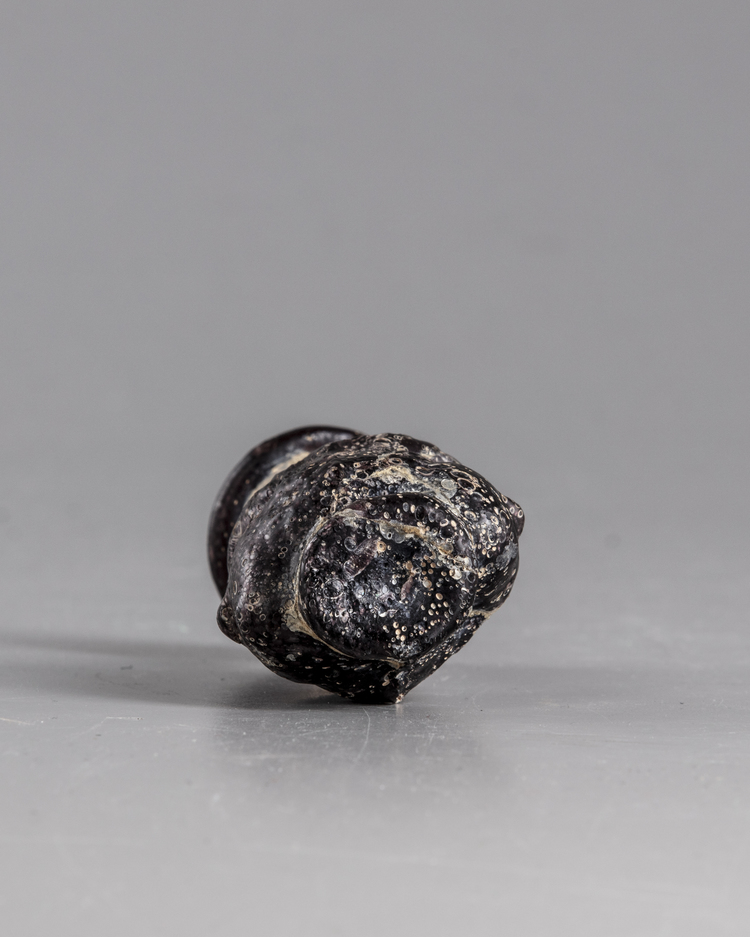 A ROMAN MOULDED PURPLE GLASS HEAD FLASK, CIRCA 3RD CENTURY AD