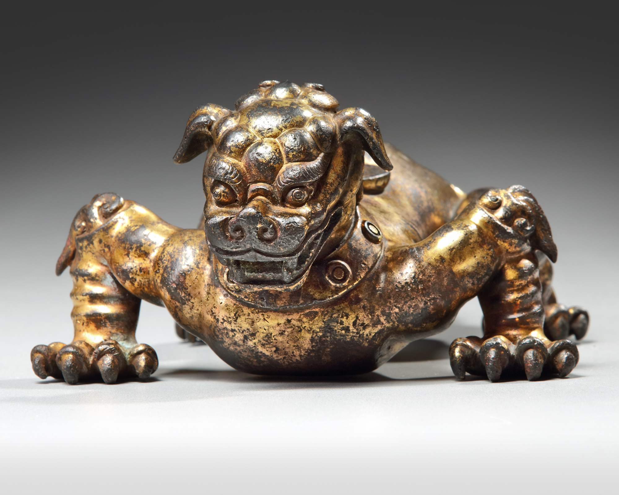 A CHINESE GILT BRONZE FIGURE OF A MYTHICAL BEAST