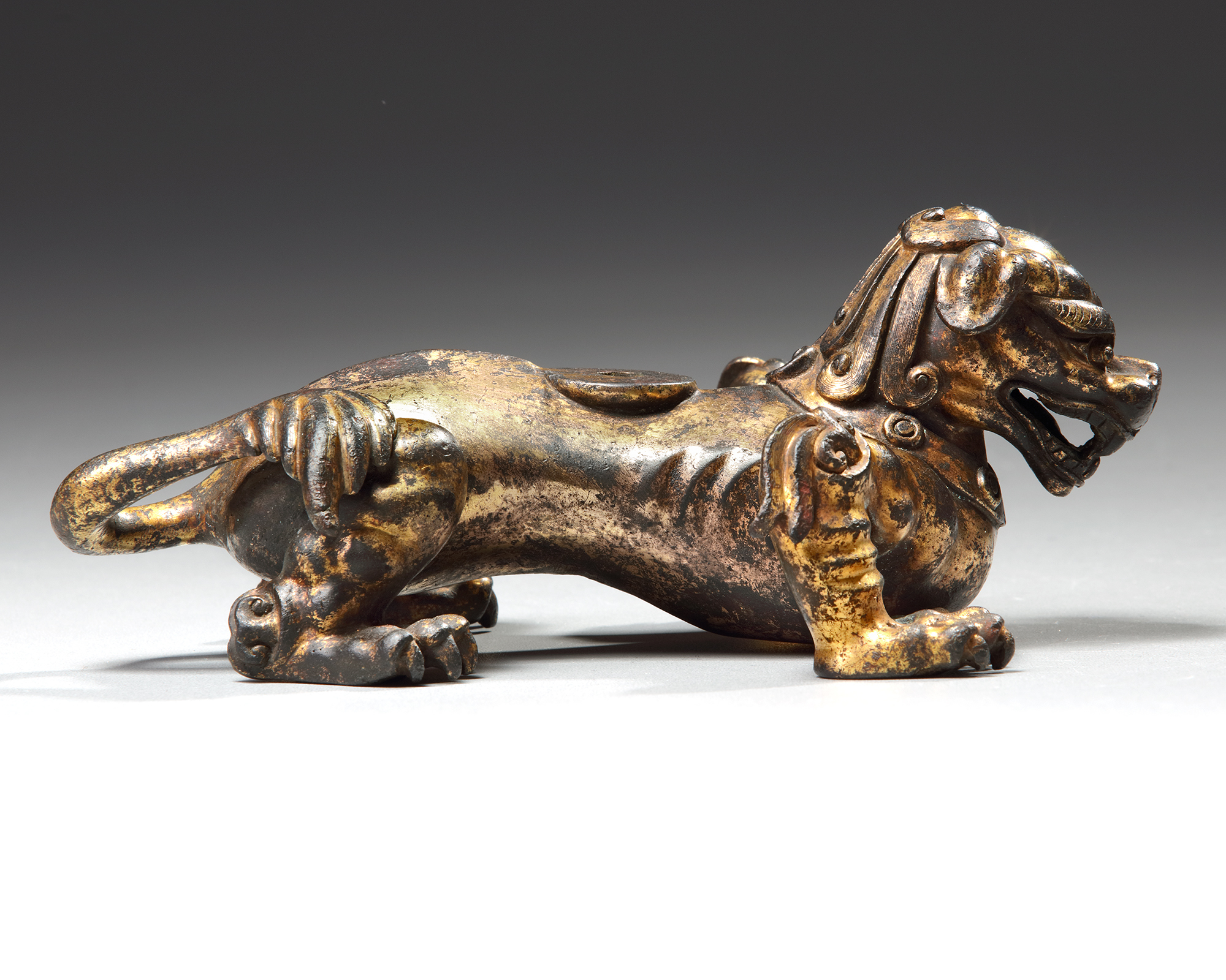 A CHINESE GILT BRONZE FIGURE OF A MYTHICAL BEAST