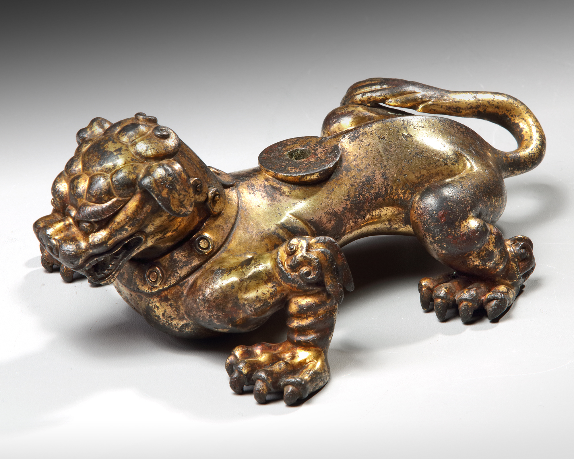 A CHINESE GILT BRONZE FIGURE OF A MYTHICAL BEAST