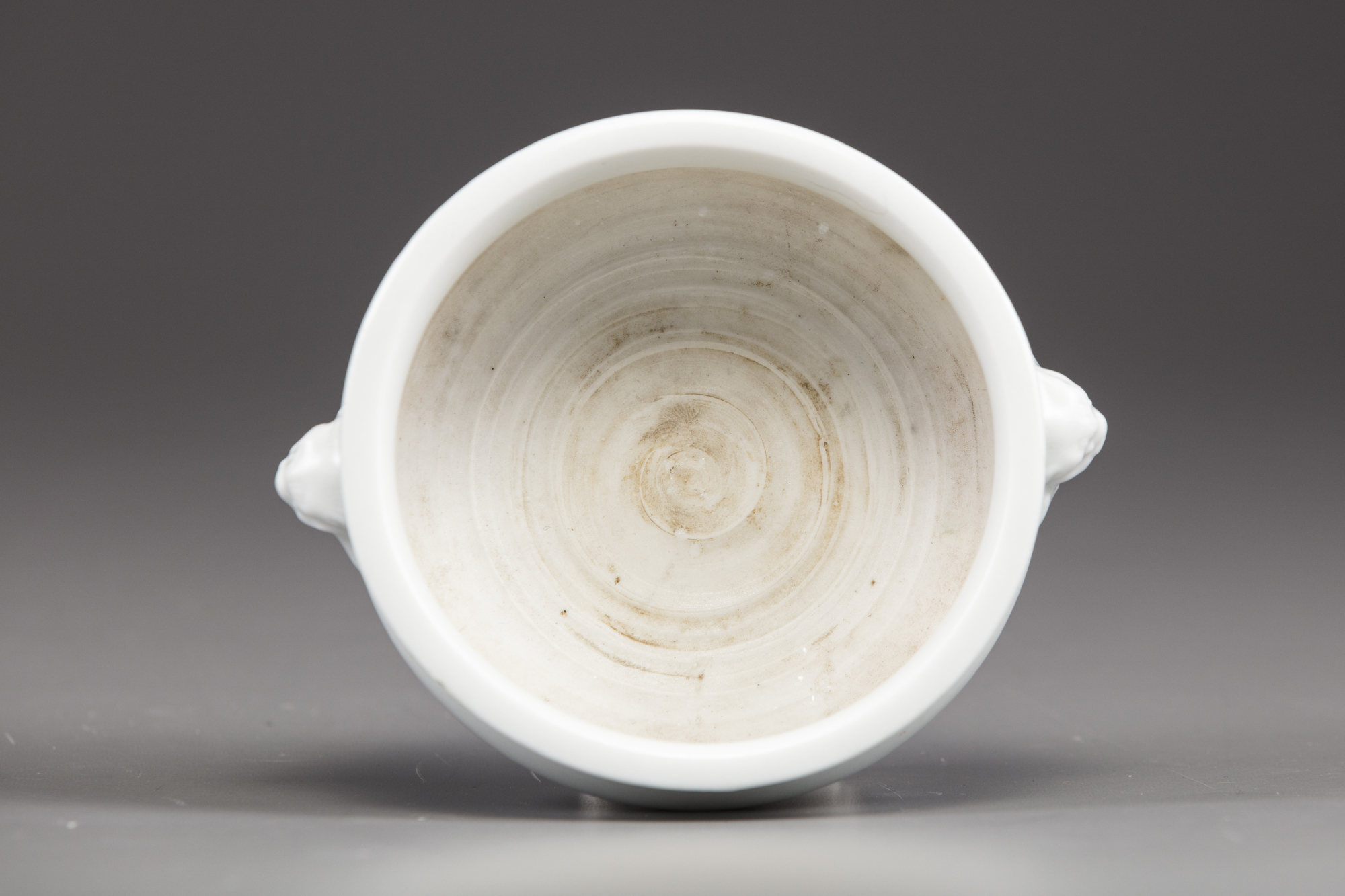 A Chinese white-glazed censer with two lion-head handles