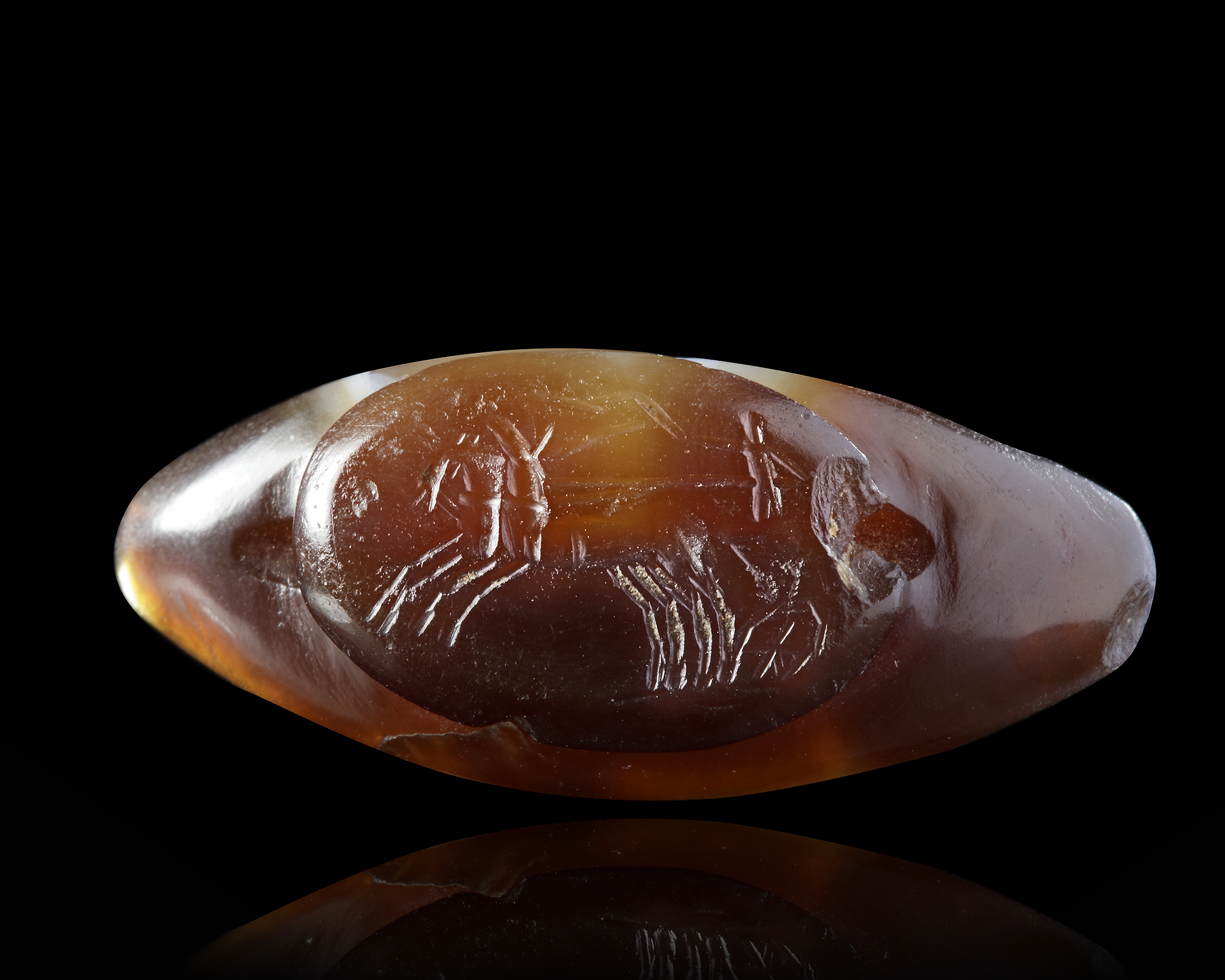 A SARDONYX CARVED BEAD WITH AN INTAGLIO OF A BIGA ADDED IN ROMAN TIMES ...
