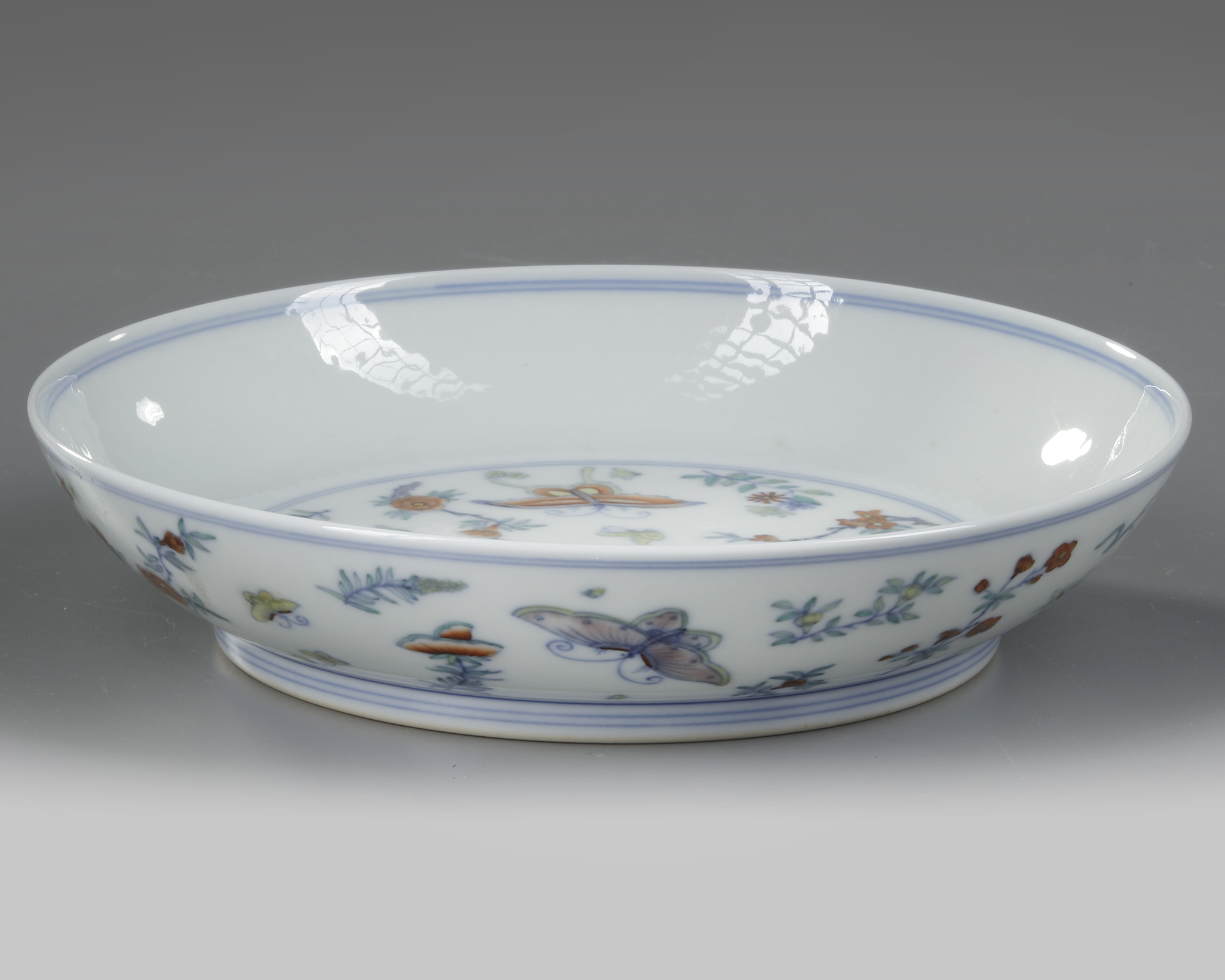 A CHINESE DOUCAI SAUCER DISH, 19TH-20TH CENTURY