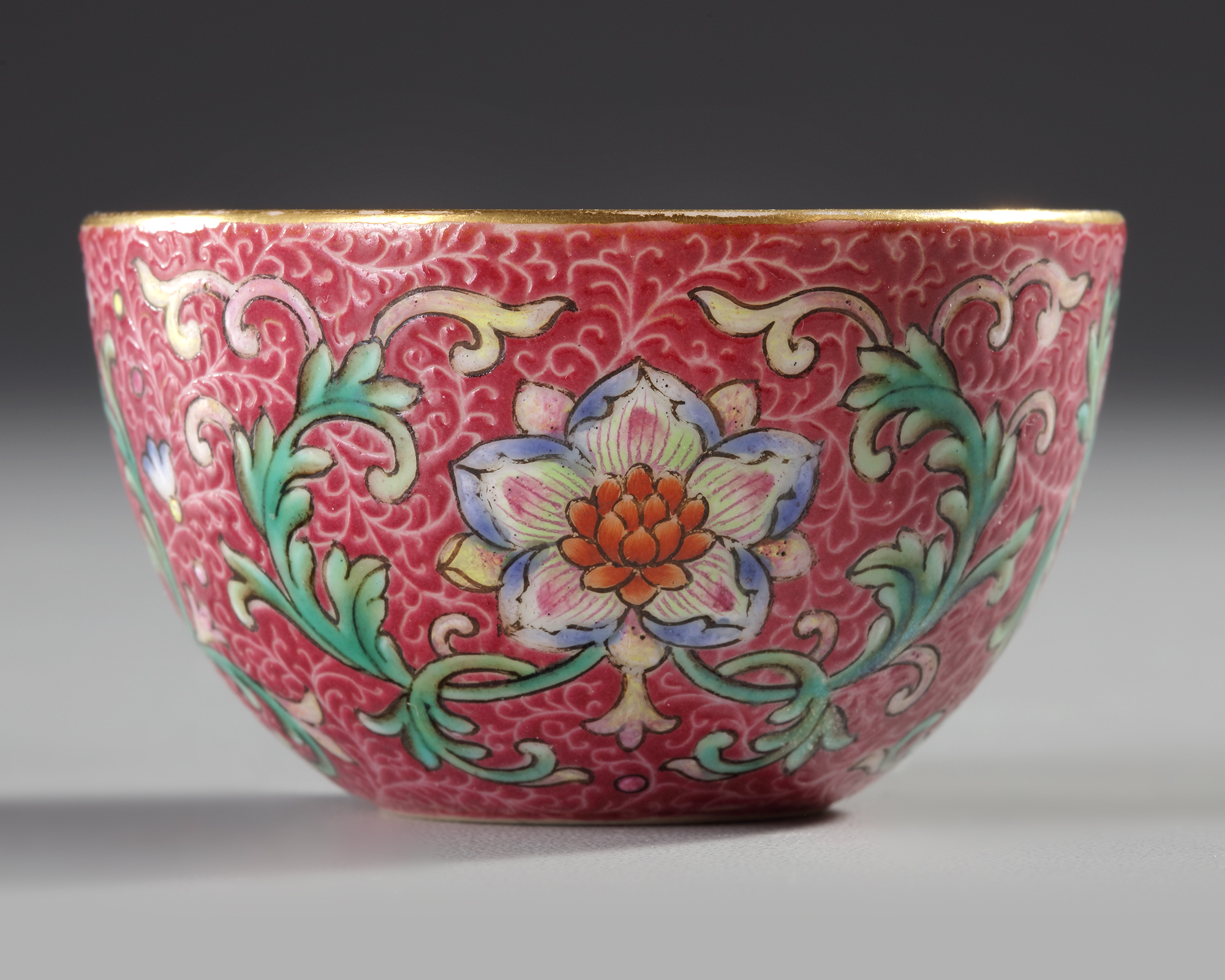 A CHINESE RUBY-GROUND FAMILLE ROSE CUP, 19TH CENTURY