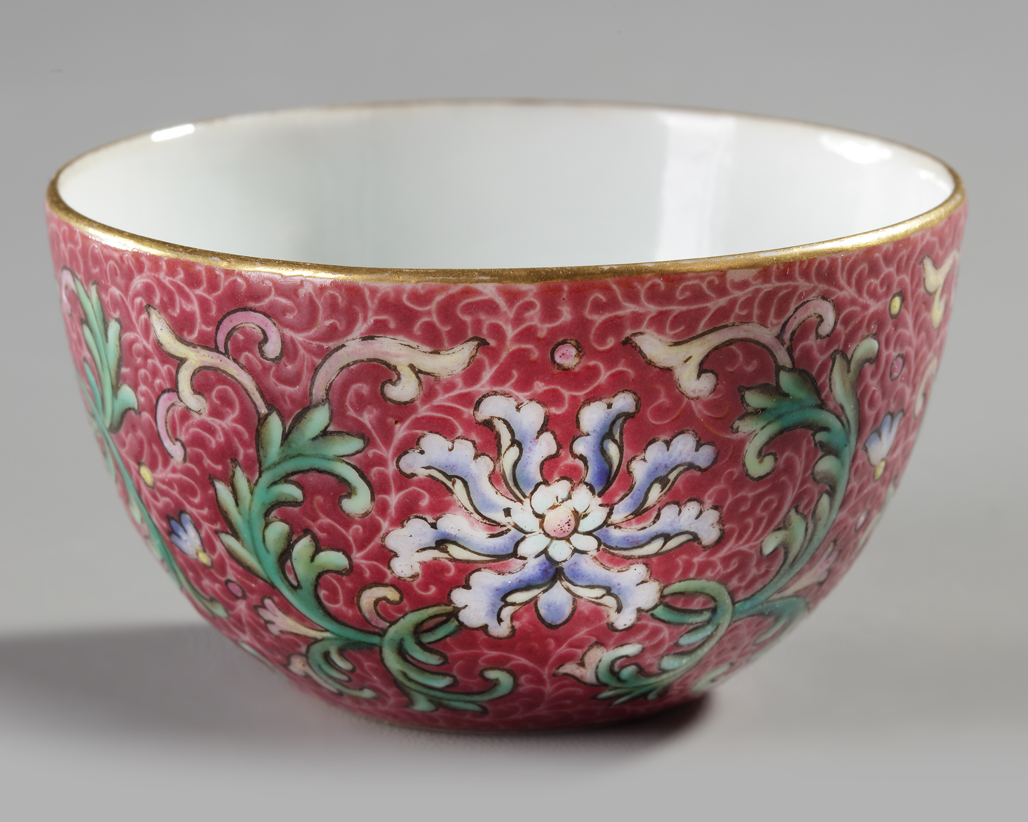 A CHINESE RUBY-GROUND FAMILLE ROSE CUP, 19TH CENTURY