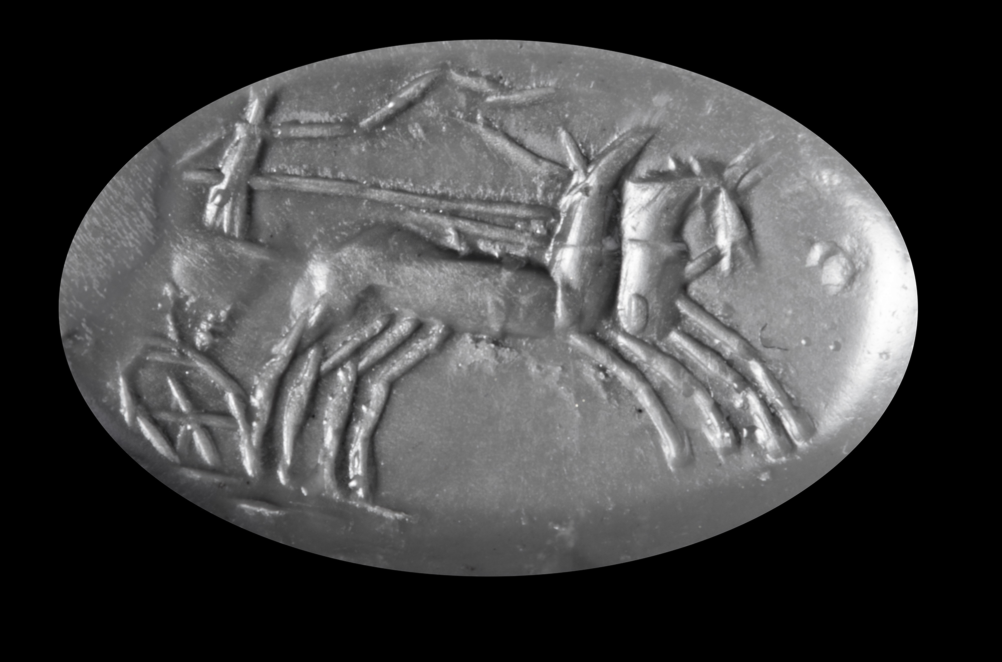 A SARDONYX CARVED BEAD WITH AN INTAGLIO OF A BIGA ADDED IN ROMAN TIMES ...