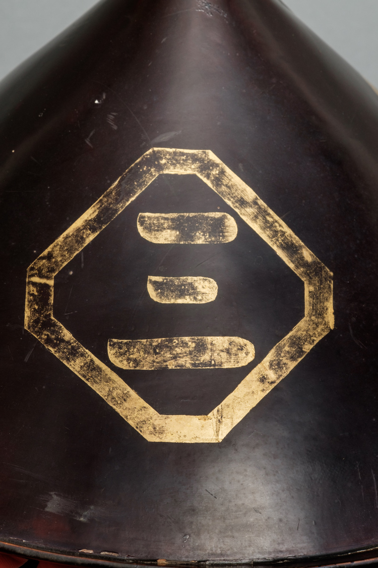 A conical black lacquered samurai hat (jingasa)