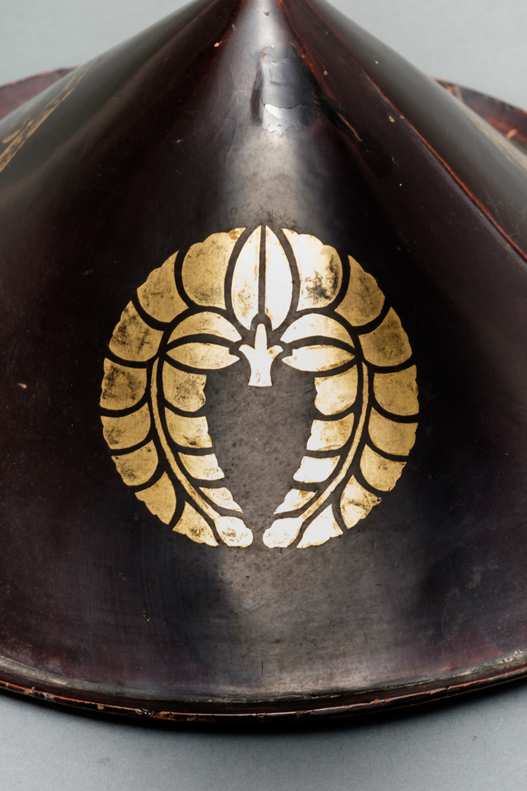 A conical black lacquered samurai hat (jingasa)