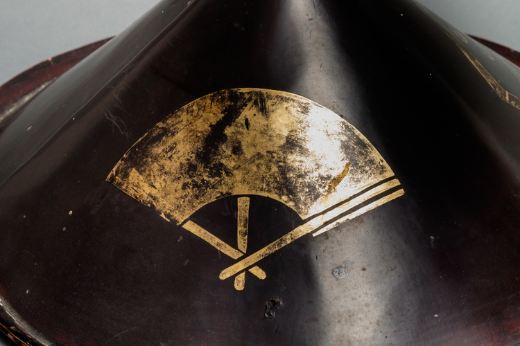 A conical black lacquered samurai hat (jingasa)