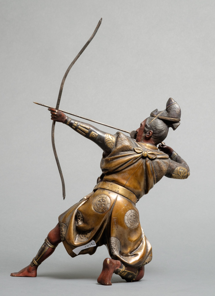 A bronze figure of a Samurai warrior resting on one knee while ...