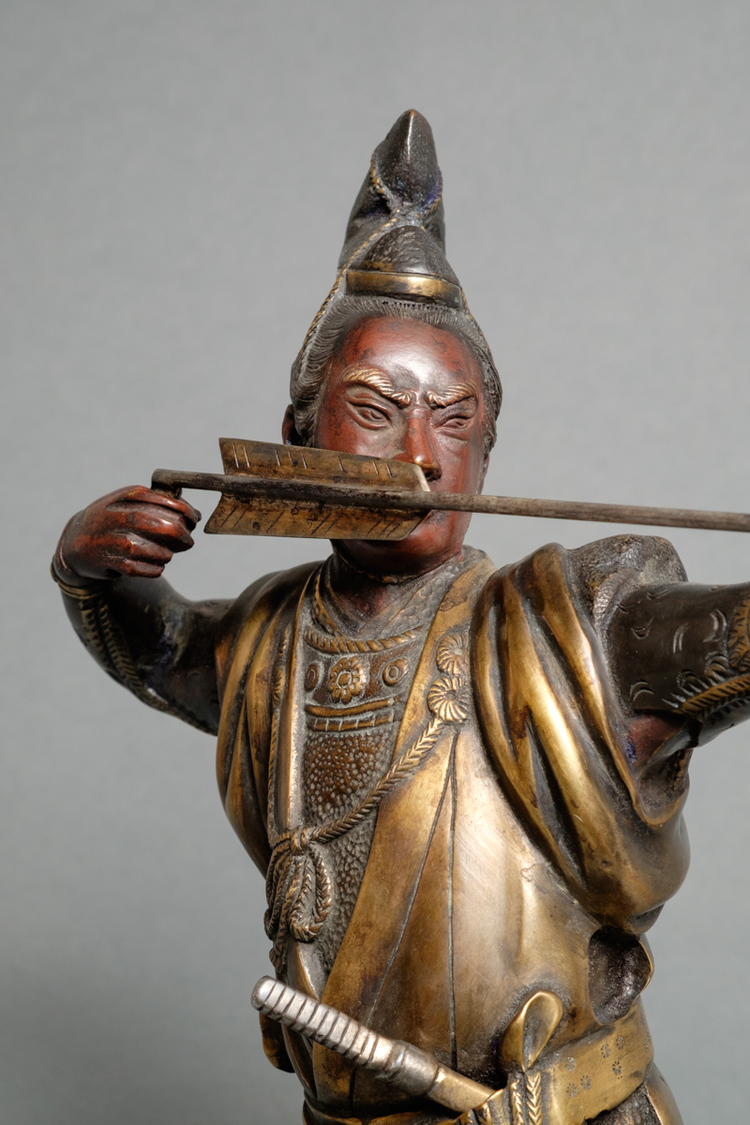 A bronze figure of a Samurai warrior resting on one knee while ...