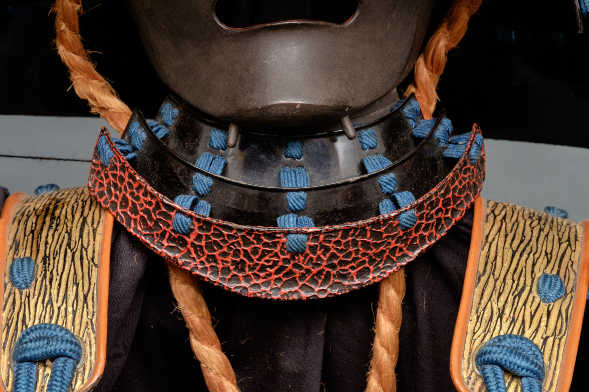 A Partly gilded suit-of-armour with indigo and light green cords