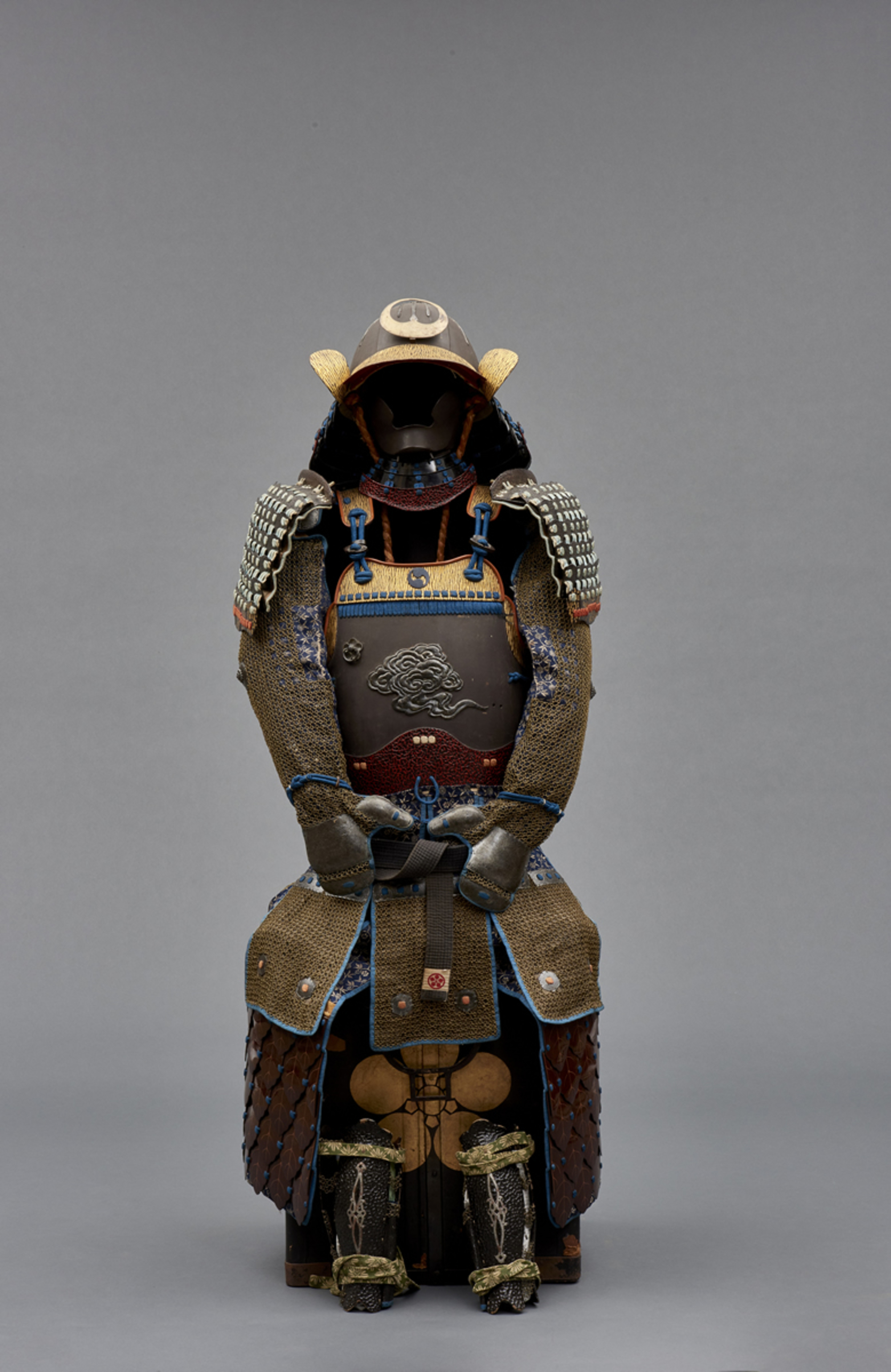 A Partly gilded suit-of-armour with indigo and light green cords